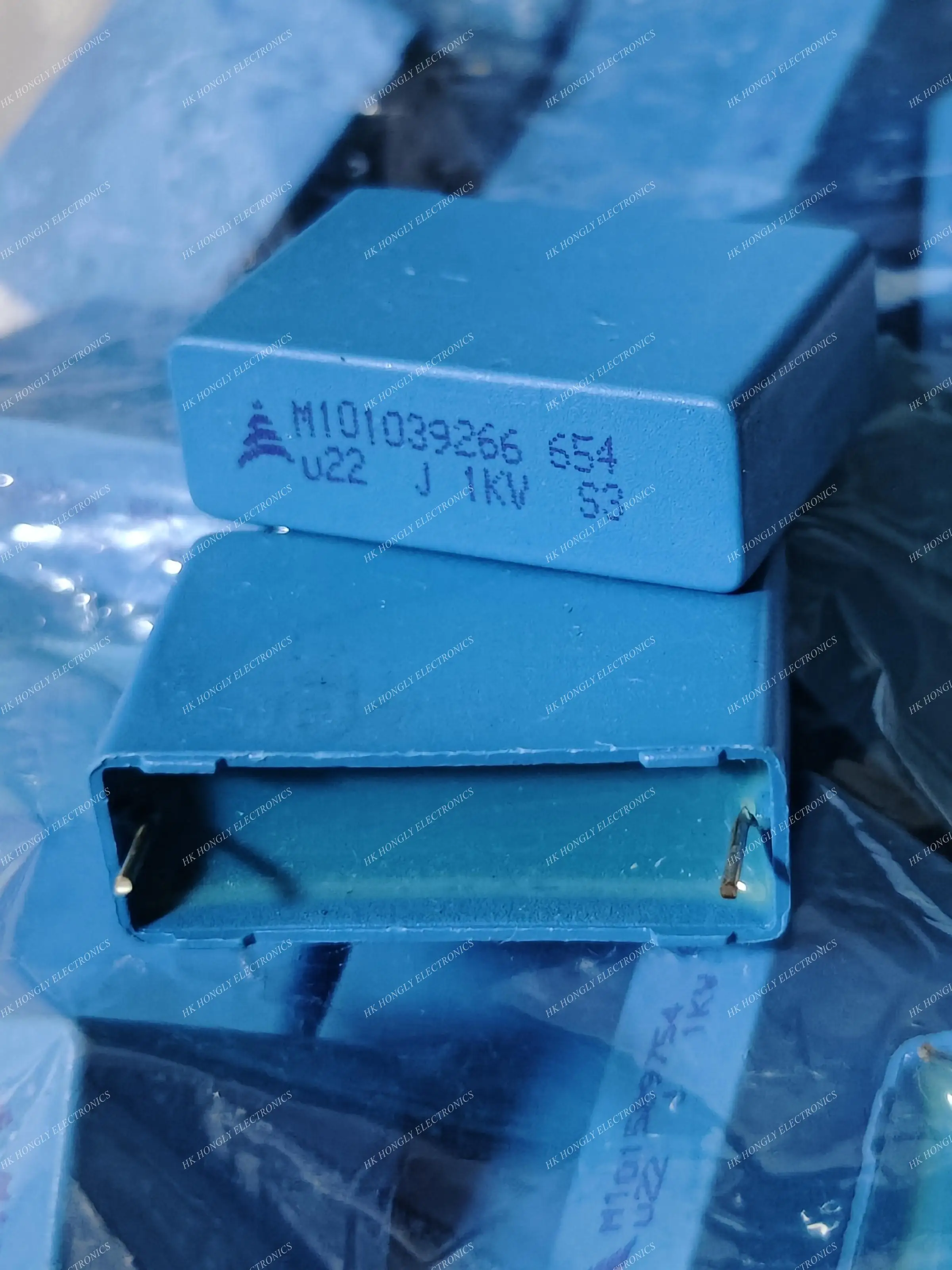 Two blue capacitors with labels indicating their specifications. These capacitors are likely ...